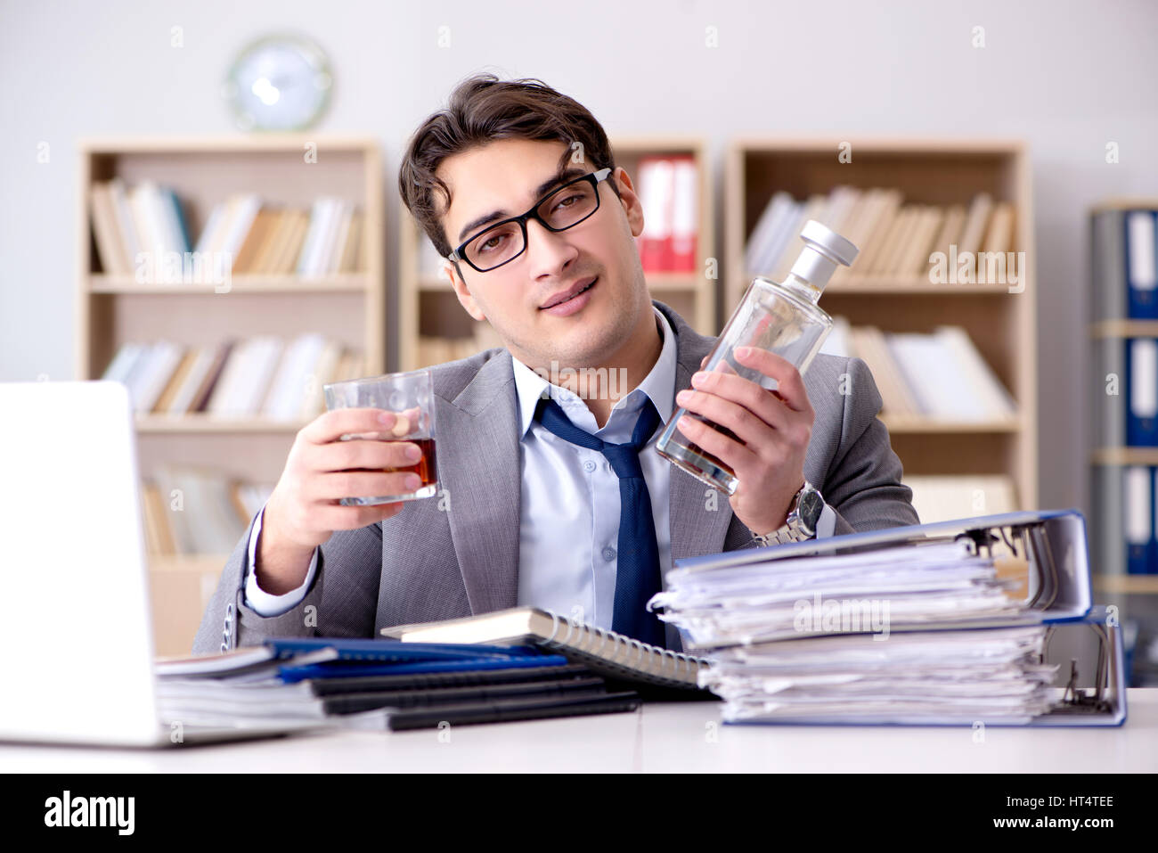 Young businessman drinking from stress Stock Photo - Alamy