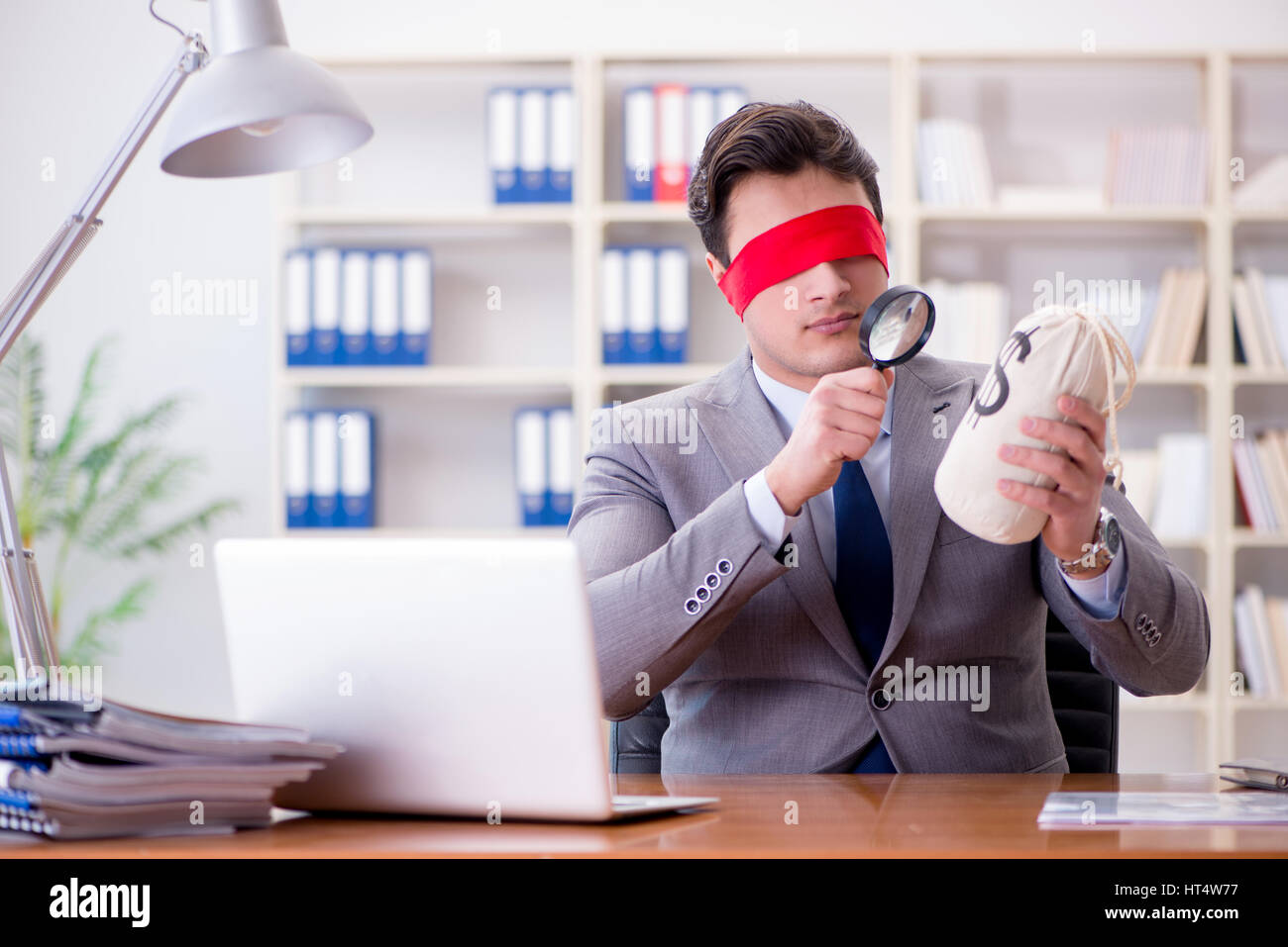 Blindfold businessman sitting at desk in office Stock Photo - Alamy