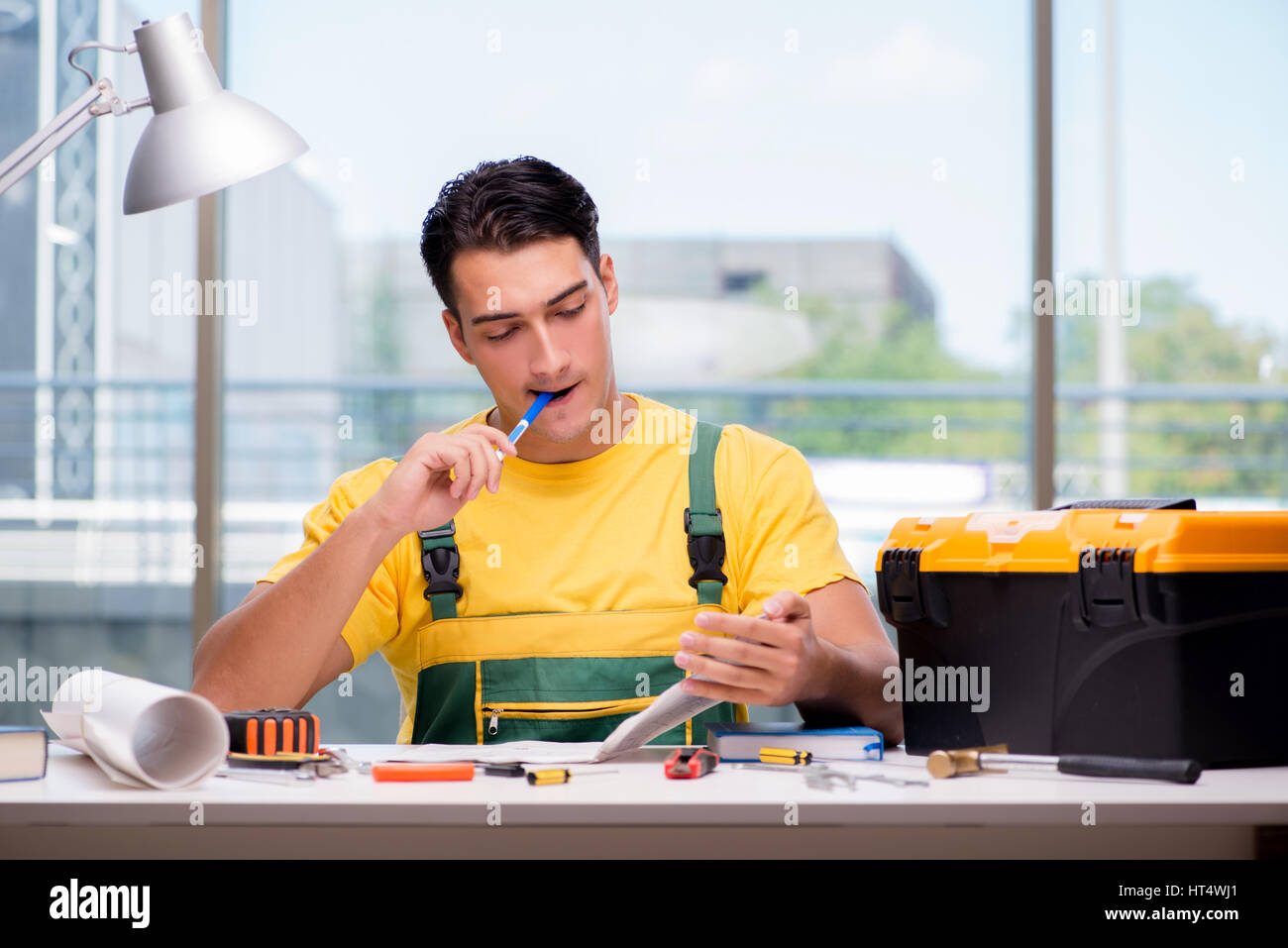 Construction worker sitting at the desk Stock Photo - Alamy