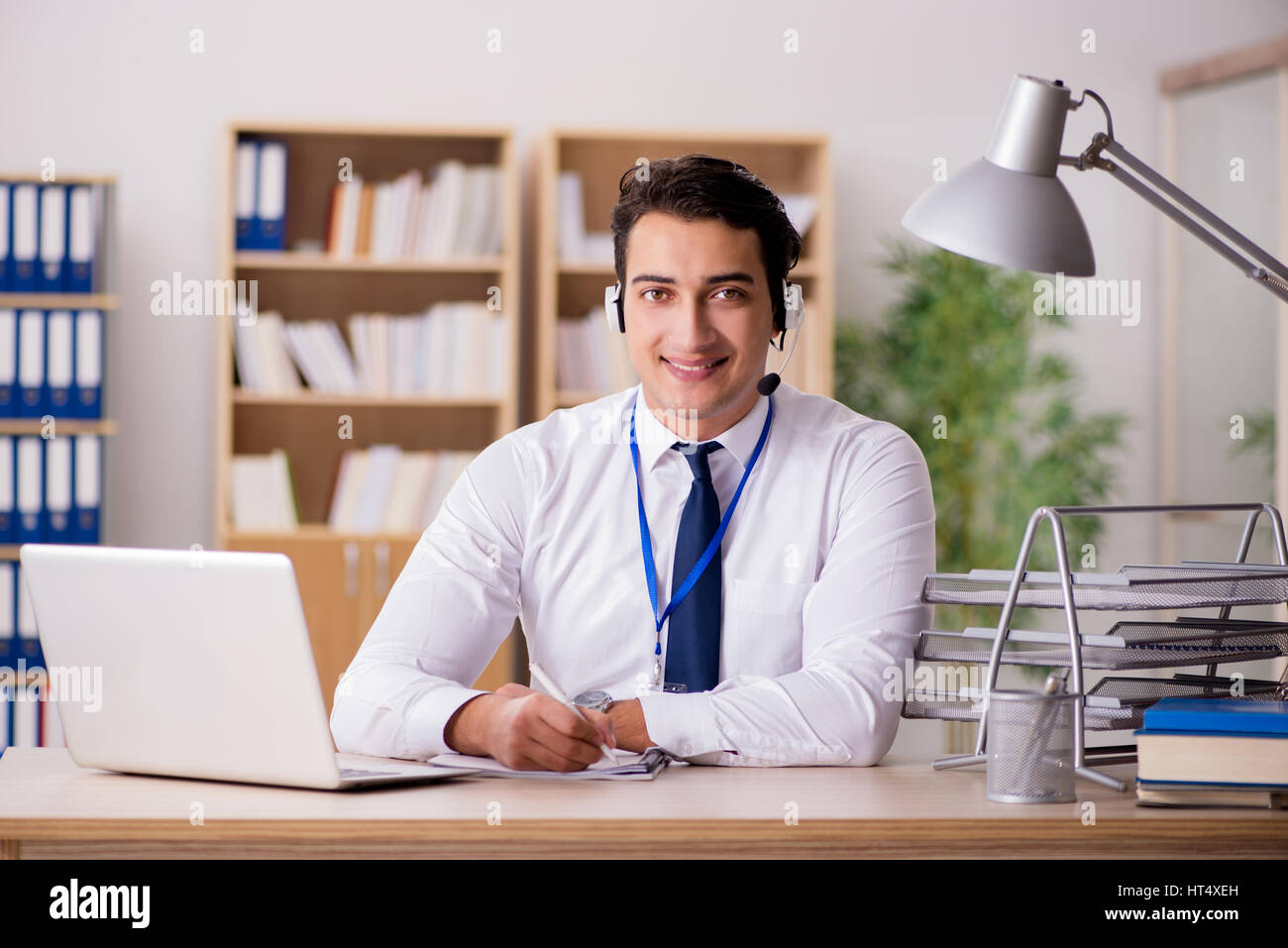 Handsome customer service clerk with headset Stock Photo - Alamy