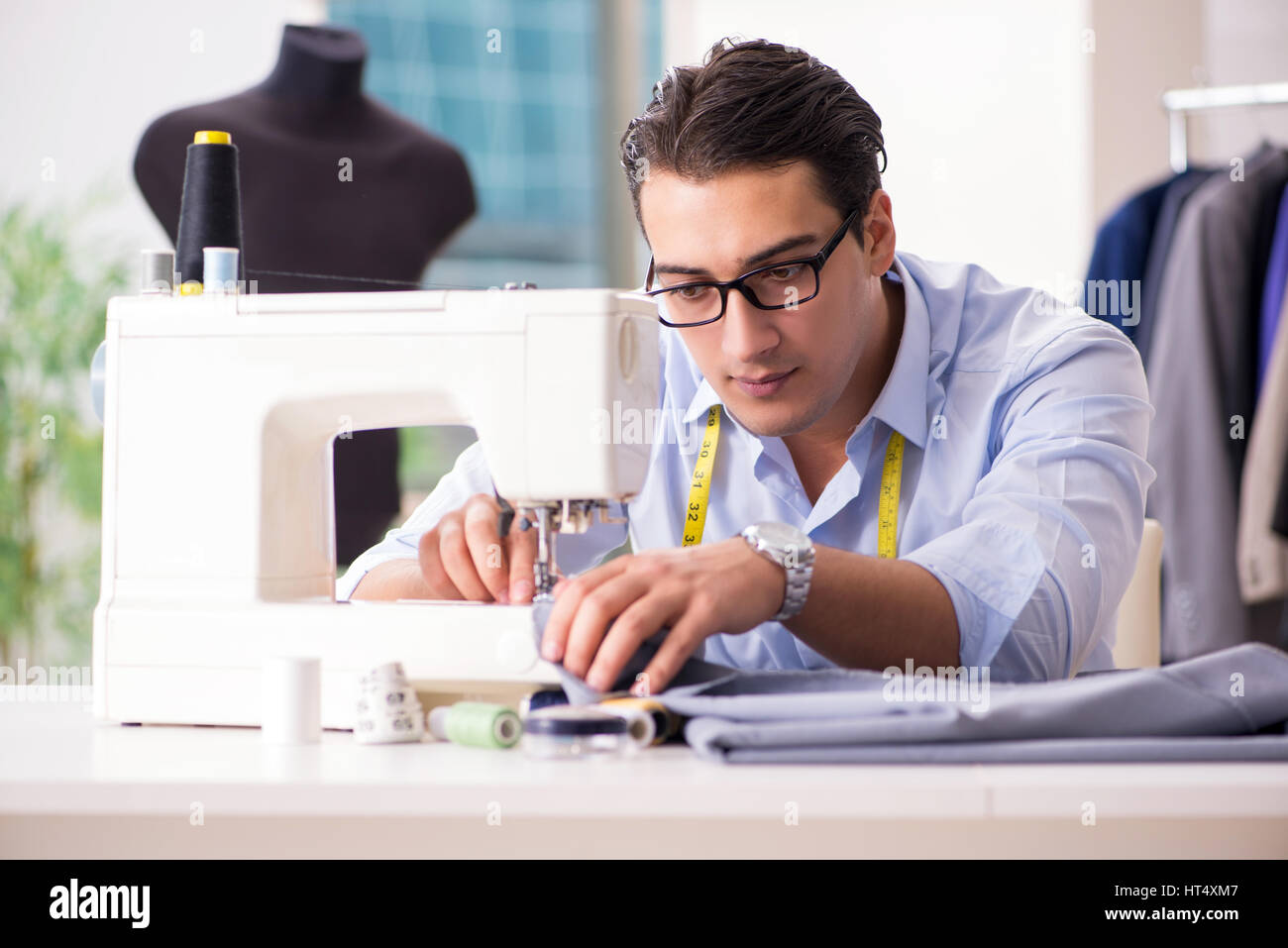 Young man tailor working on new clothing Stock Photo - Alamy