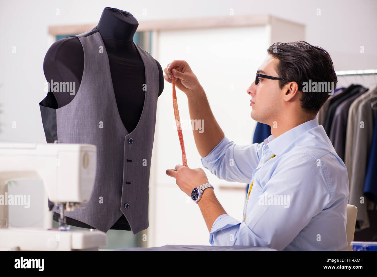 Young man tailor working on new clothing Stock Photo - Alamy
