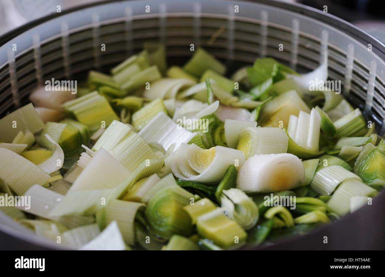 Washing grit from cut leeks in a colander Stock Photo - Alamy