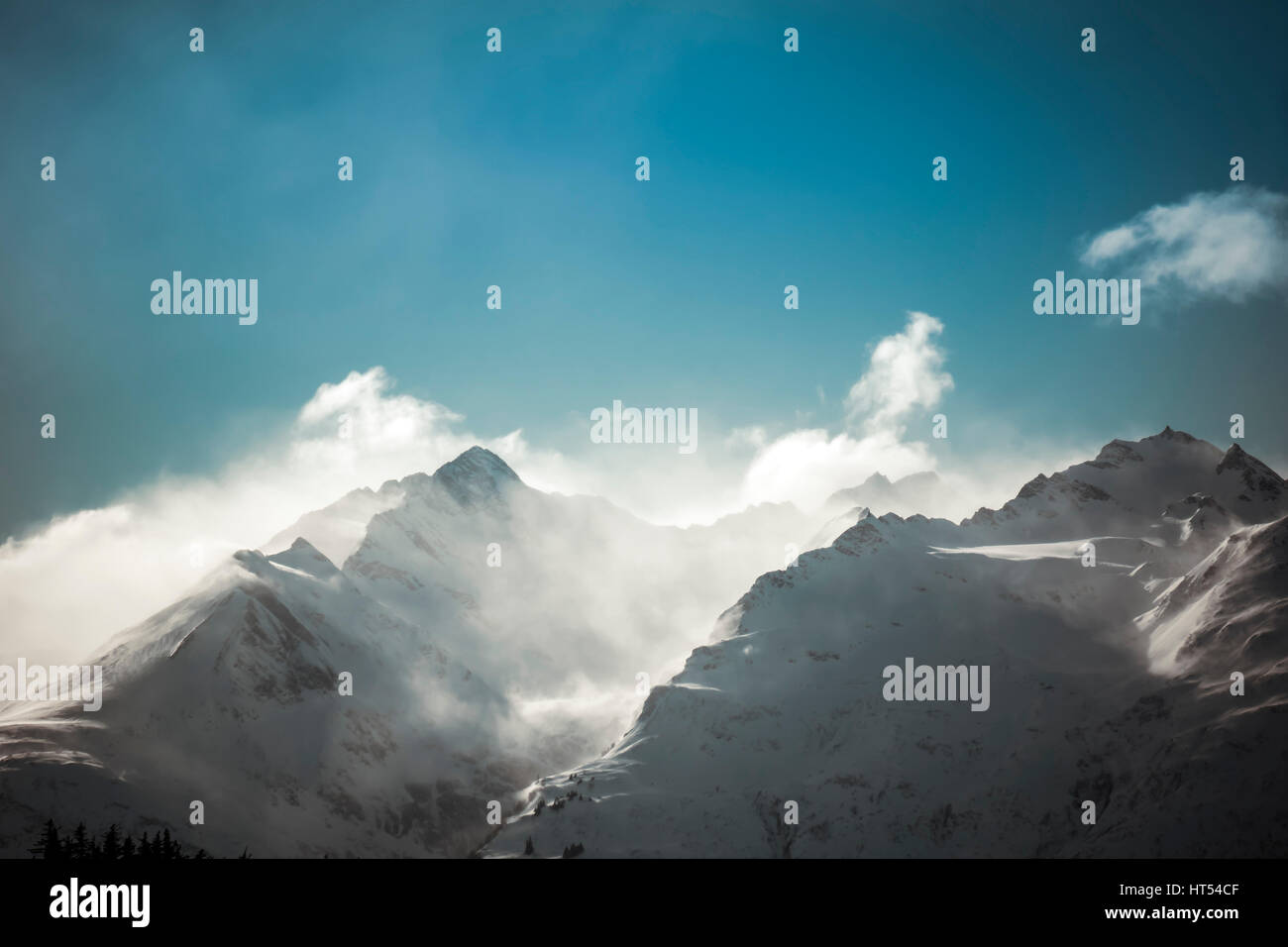 Mountain peaks near Haines Alaska with fog and blowing snow on a windy ...