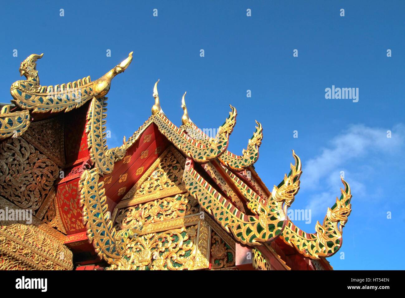Details of northern style Thai temple roof against clear blue sky at ...