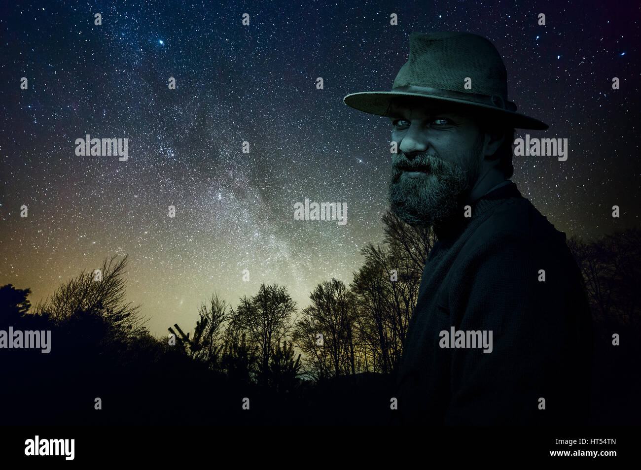 Scary man in hat and beard at night in a creepy forest Stock Photo - Alamy