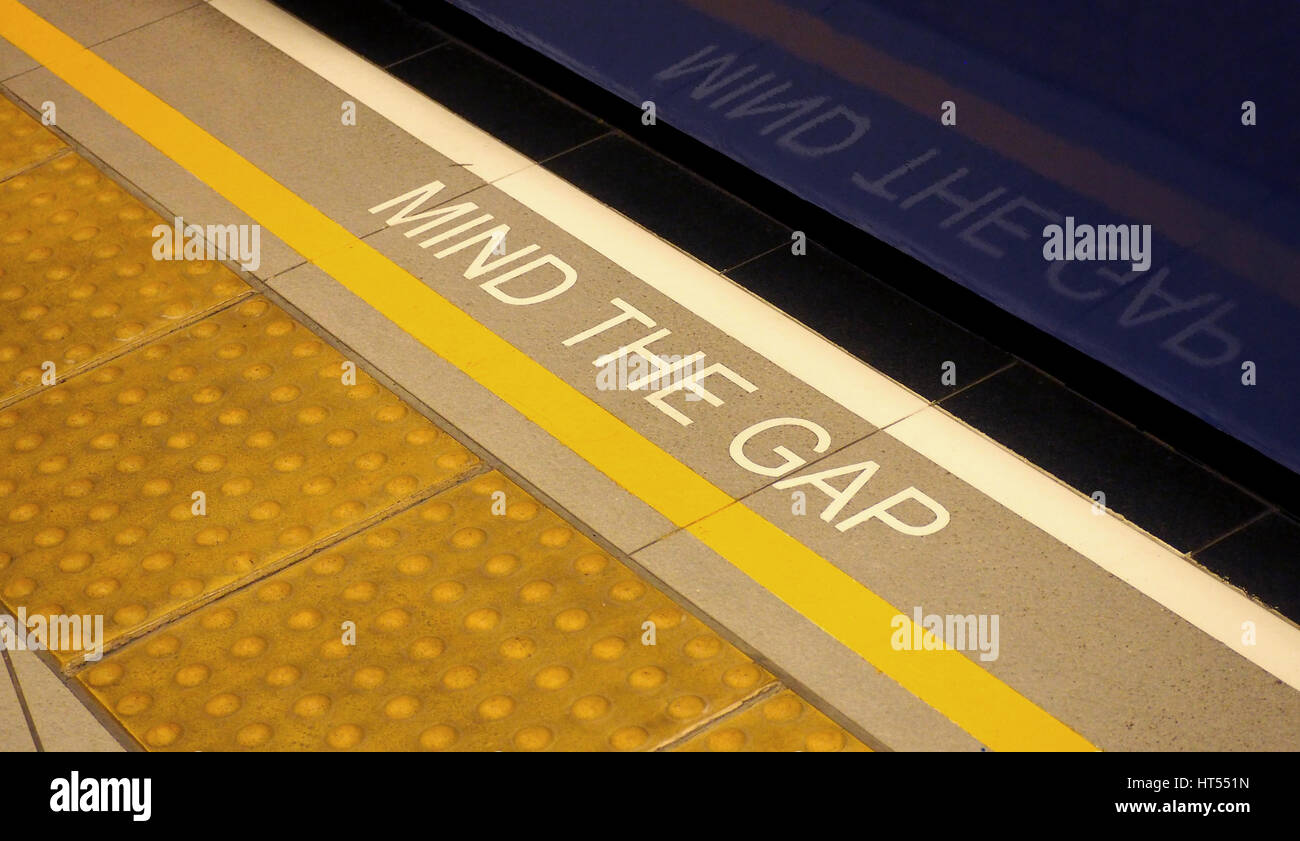 Mind the gap sign on the subway train platform floor and yellow color ...