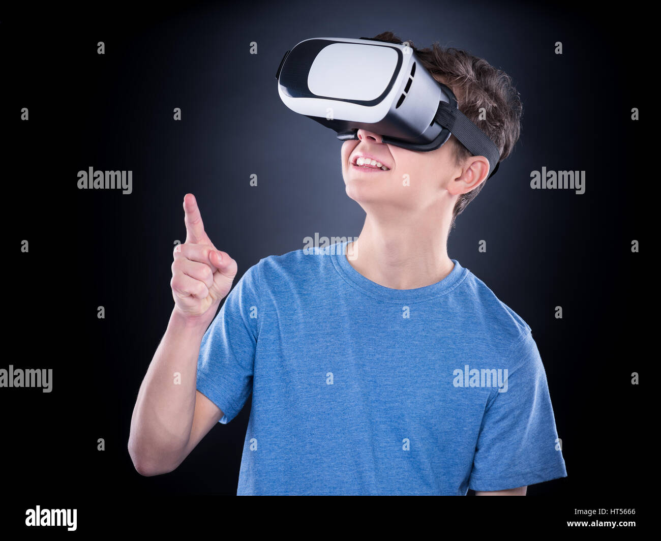 Happy teen boy wearing virtual reality goggles playing video games, on ...