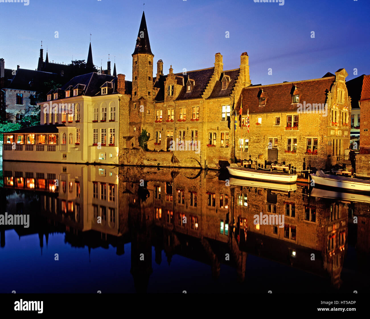 Medieval buildings reflecting in the Dijver Canal, illuminated at dusk ...