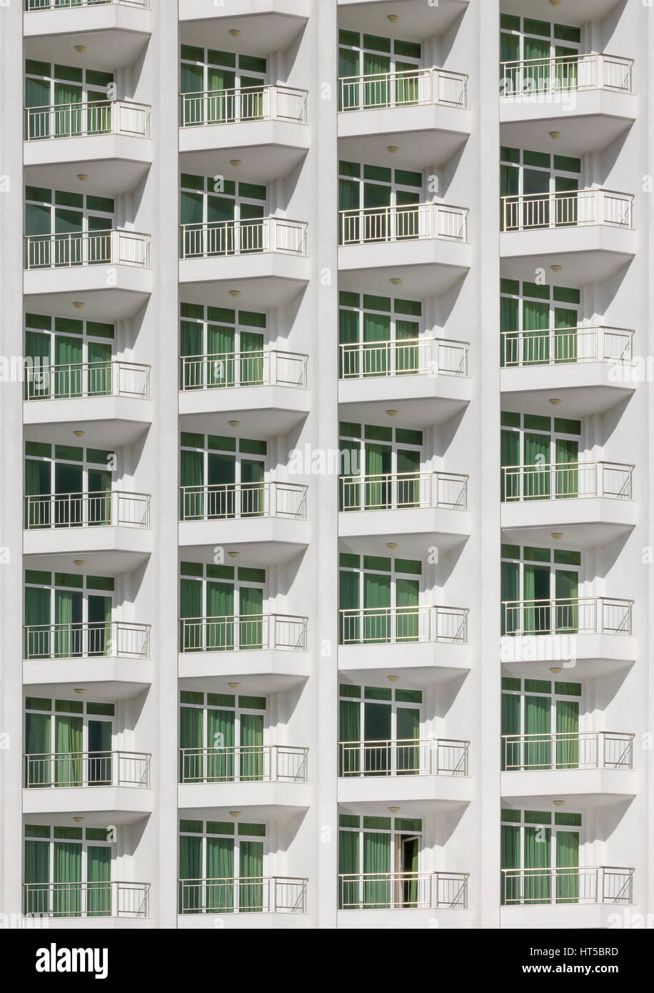 repeating pattern of windows and balcony.Building front white color ...