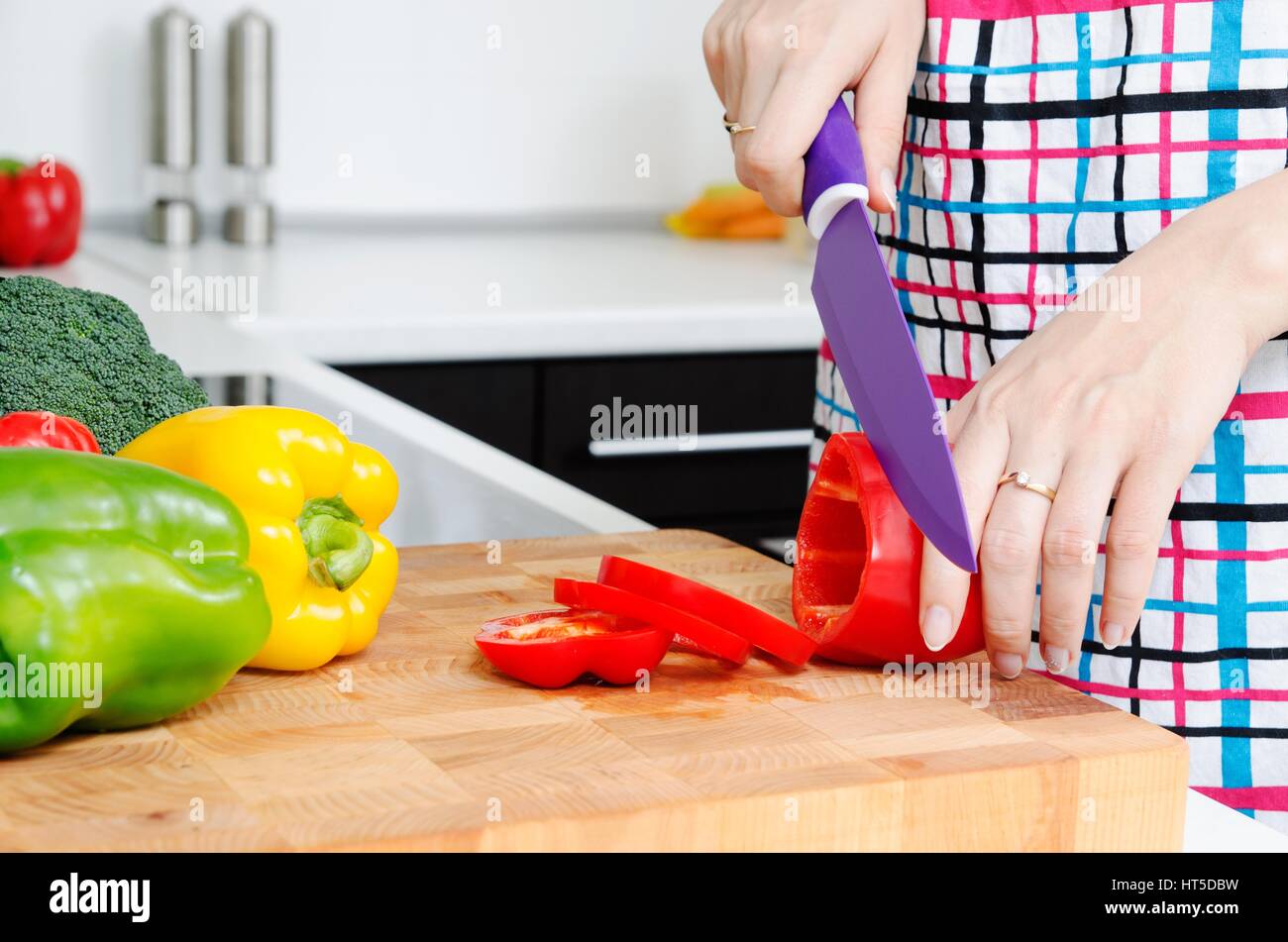 Woman chef cutting peppers. Food preparation in modern kitchen Stock ...