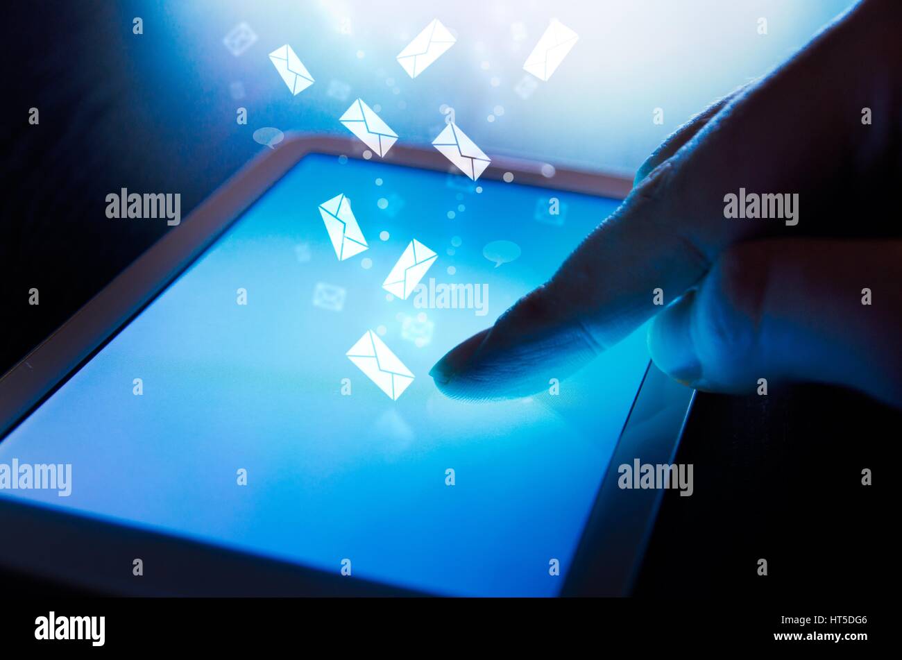 Finger touching on tablet. Messages fly from the screen Stock Photo - Alamy