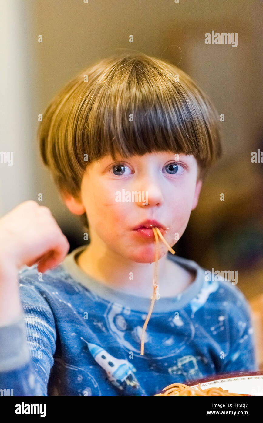 Young boy messily eating spaghetti Stock Photo - Alamy