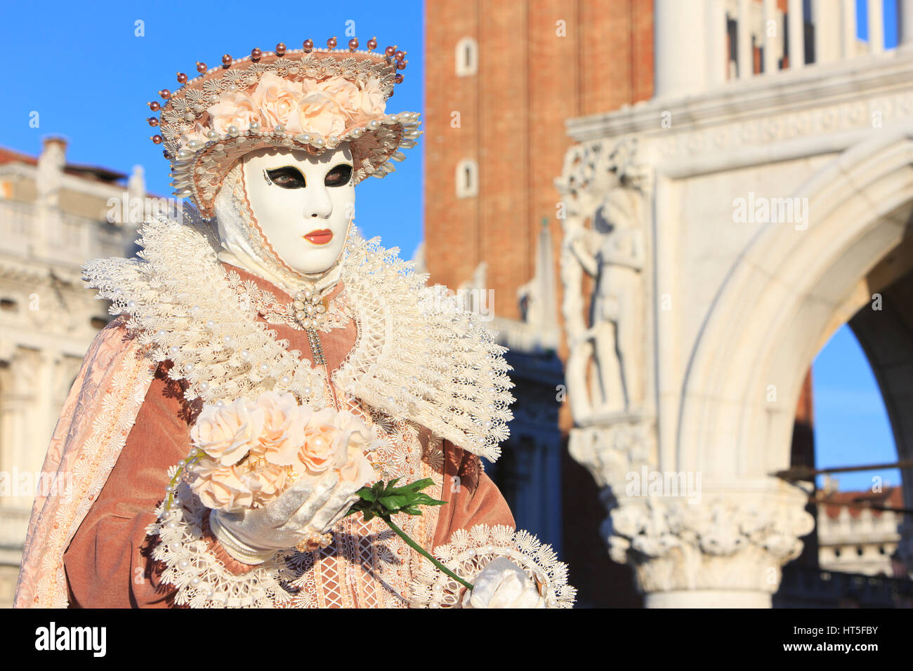 A lady in a traditional Venetian dress decorated with roses outside the ...