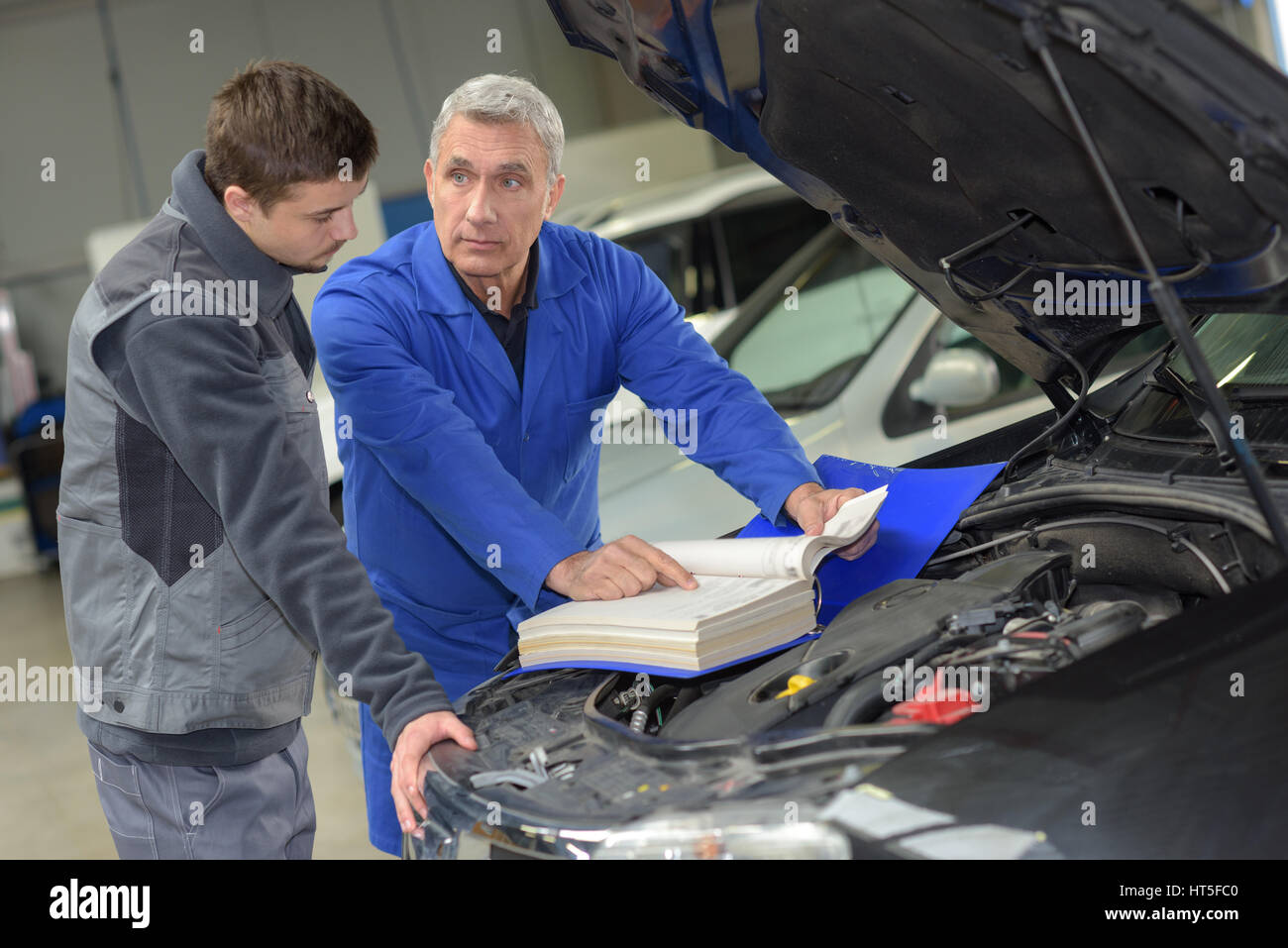 auto mechanic teacher and trainee performing tests at mechanic school ...