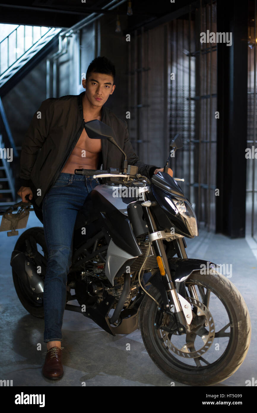 Young muscular man riding motorcycle Stock Photo - Alamy