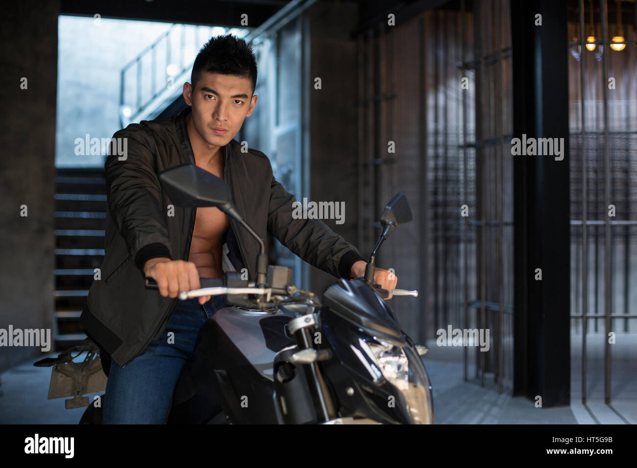 Young muscular man riding motorcycle Stock Photo - Alamy