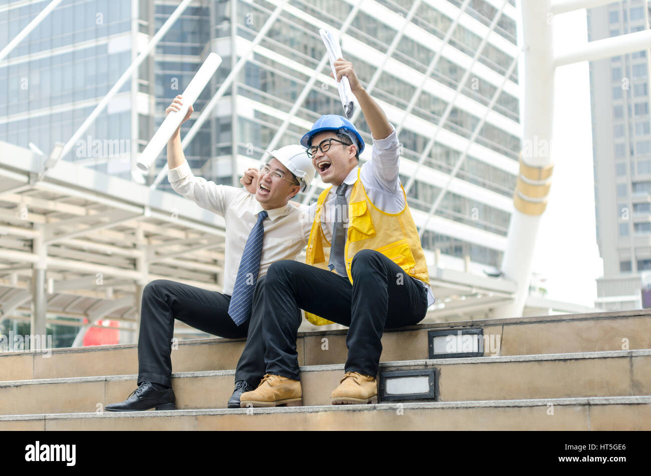 Success business concept. Two asian architects keeping hands up with ...