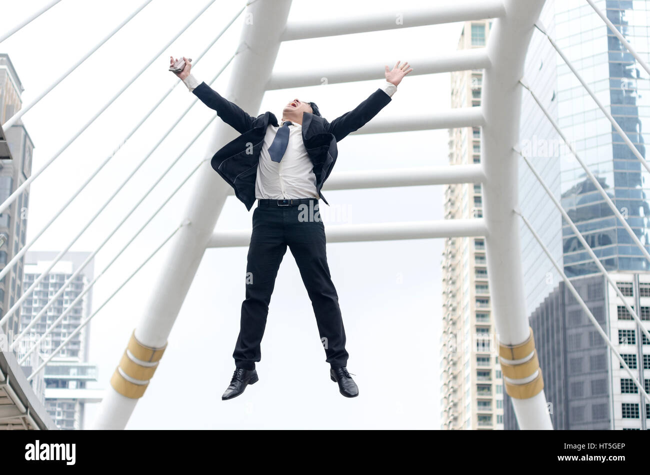 Success concept. Asian businessman jumping with happy moment and modern ...