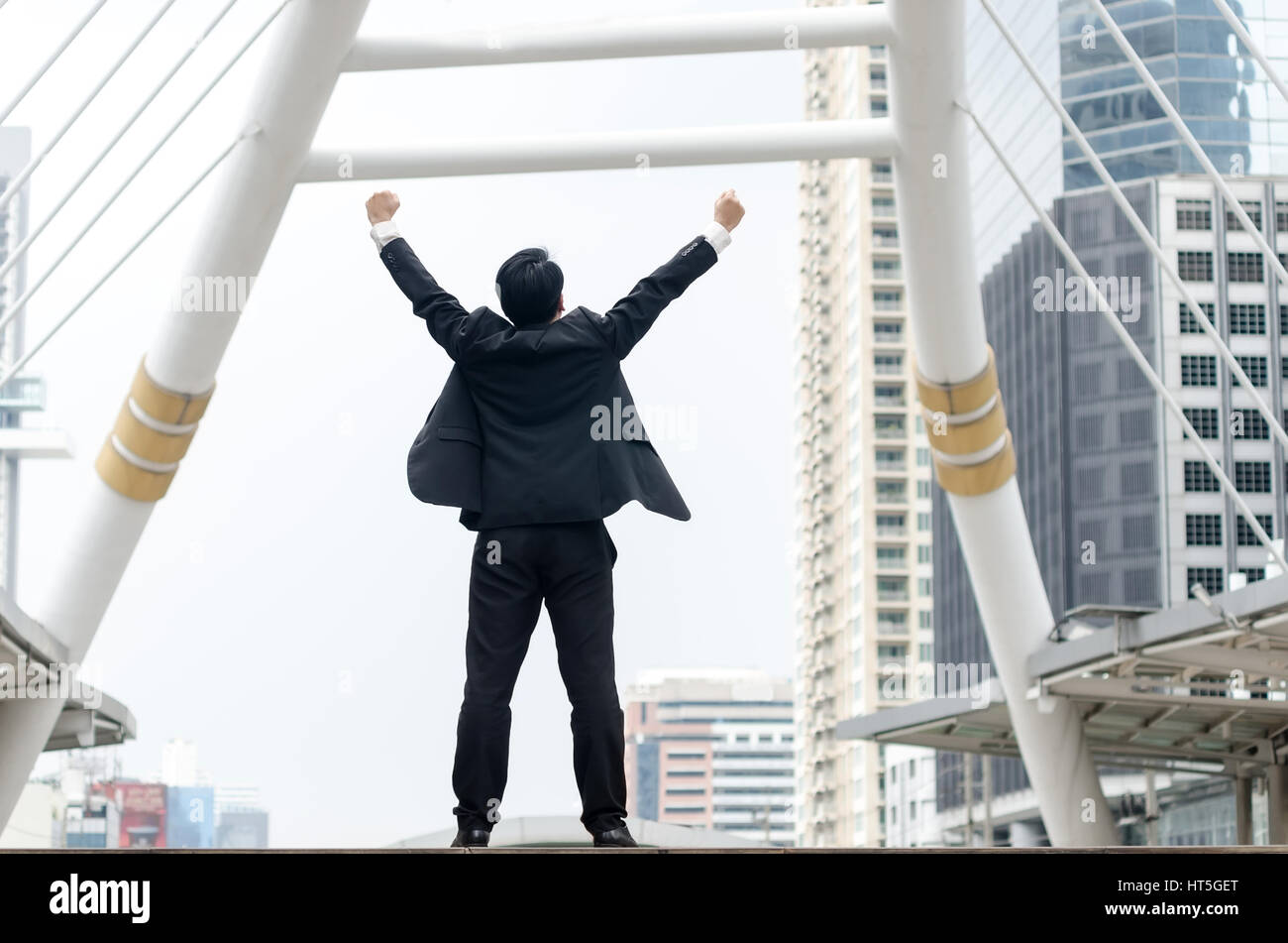 Success concept. Backside of asian businessman hands up with happy ...