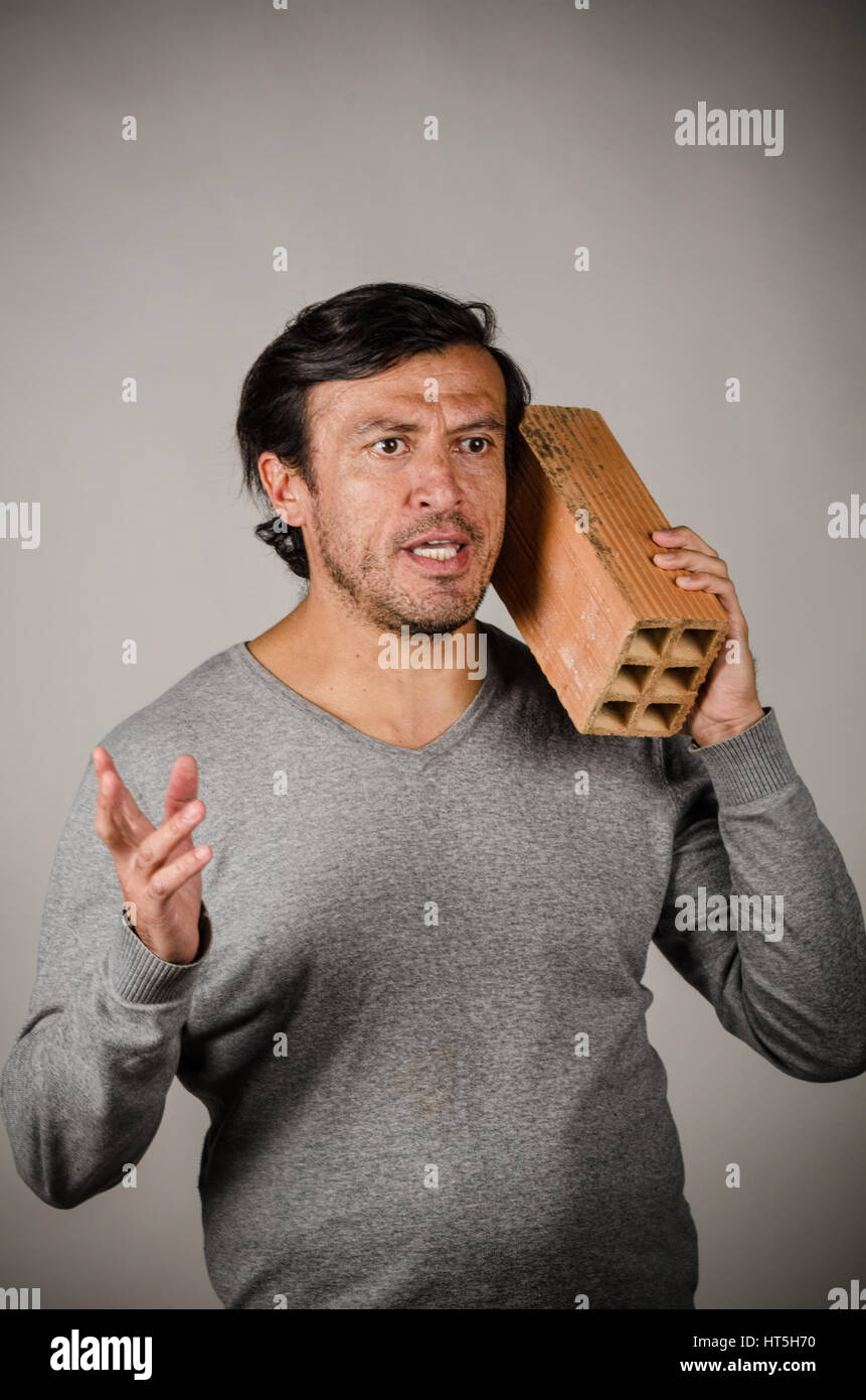 Guy using a large brick simulating a big smartphone, a funny technology ...