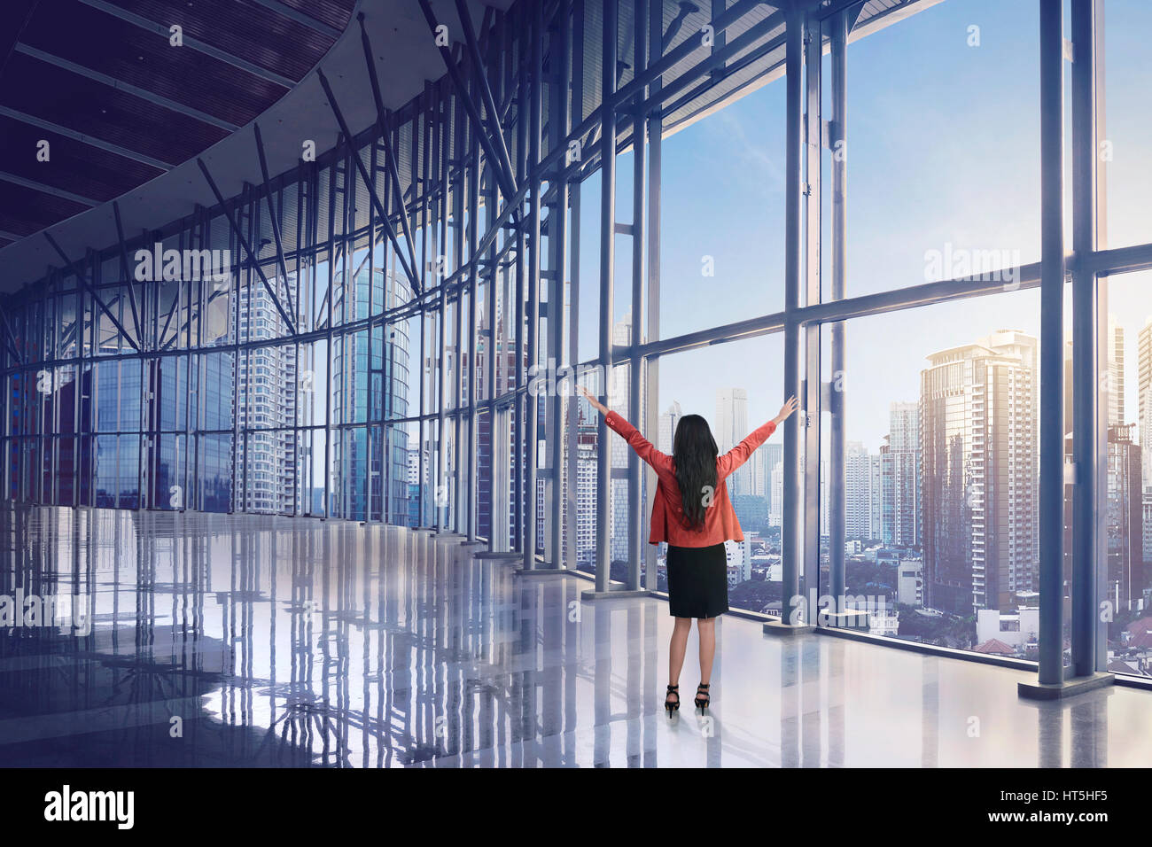 Happy asian business woman looking of skyscraper building from window ...