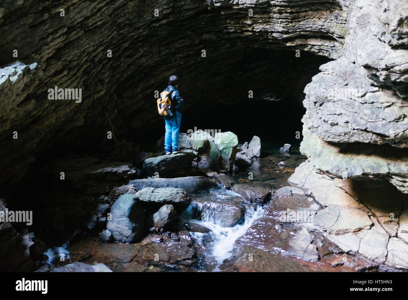 Child explore the cave with underground river, ravine Cunardo, Varese ...