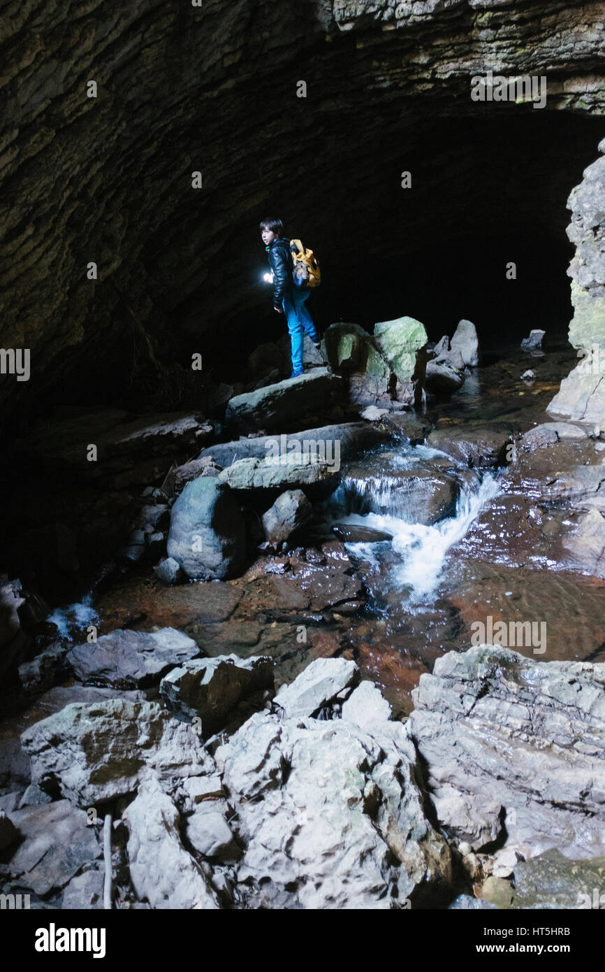 Child explore the cave with underground river, ravine Cunardo, Varese ...