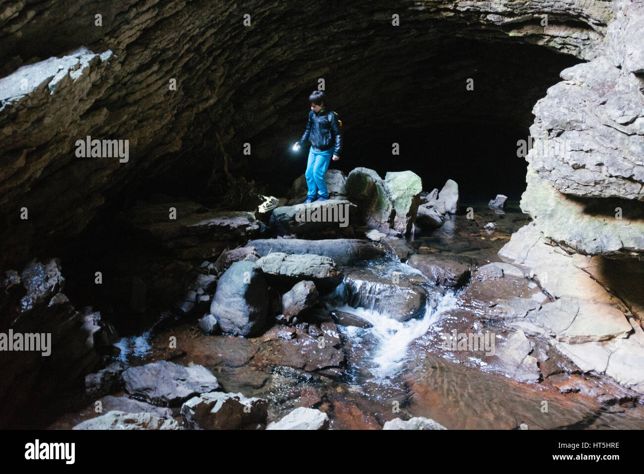 Child explore the cave with underground river, ravine Cunardo, Varese ...