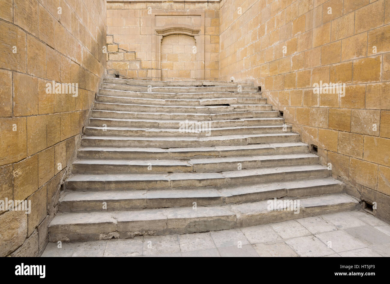 Ancient wide stone staircase, framed by stone walls from three sides ...