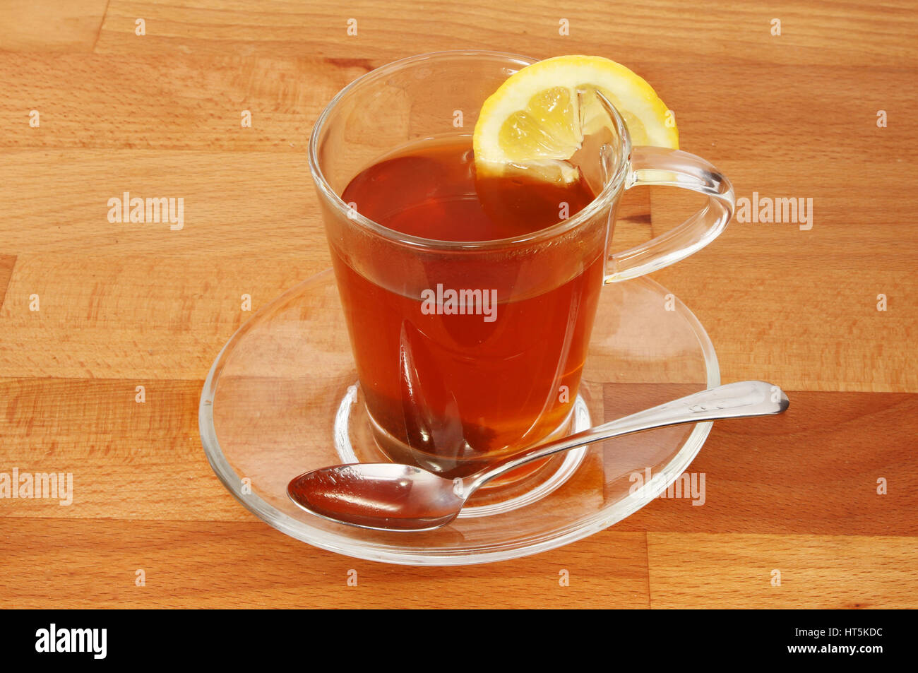 Lemon tea in a glass cup and saucer on a wooden worktop Stock Photo - Alamy