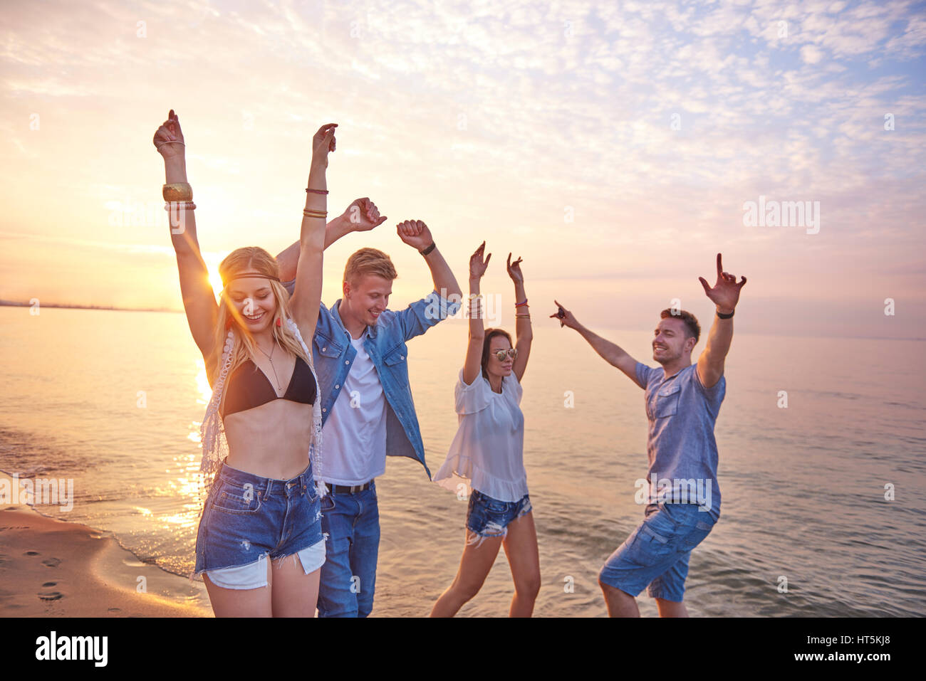 Dancing during sunset on the beach Stock Photo - Alamy
