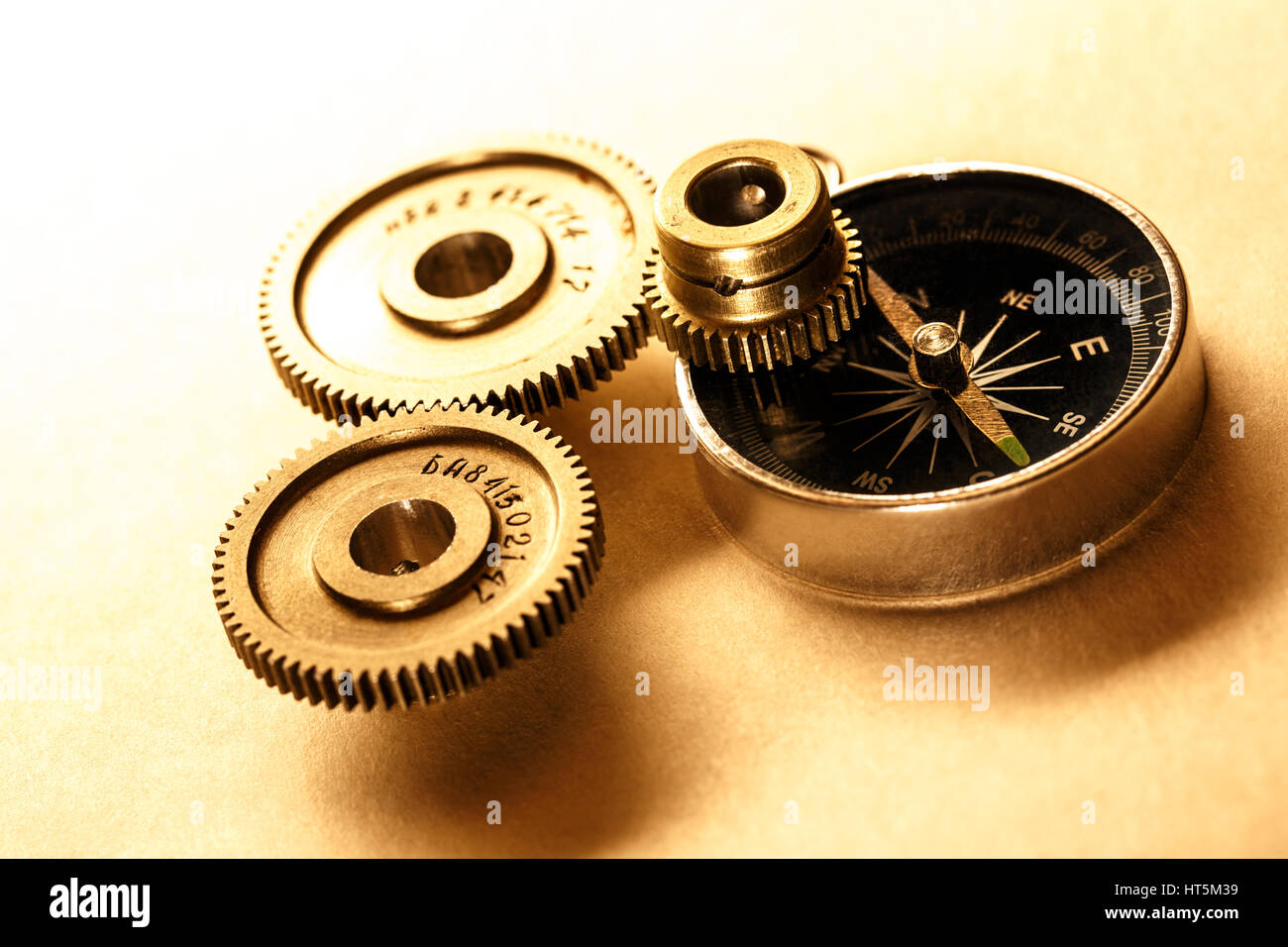 Three steel cogwheels with compass in closeup Stock Photo - Alamy