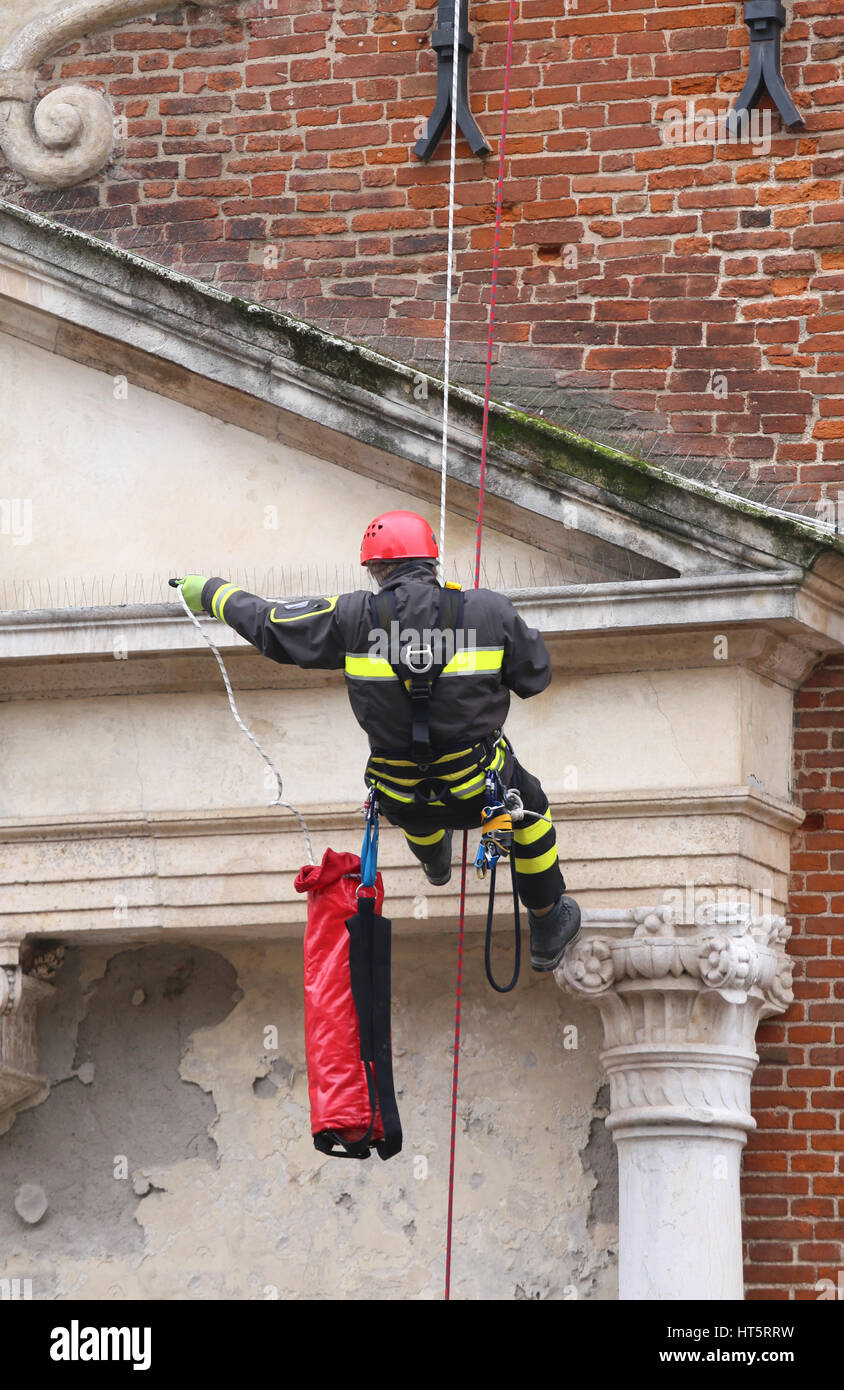 firefighters climbing with ropes and climbing equipment on an old ...