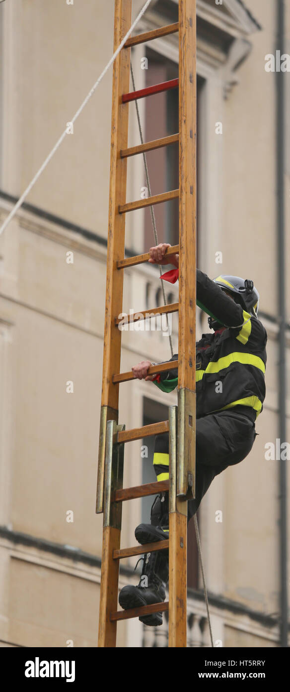 brave firefighter over a wooden stairs during a fire-fighting exercise ...