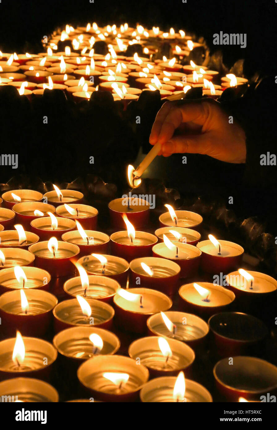 many candles lit in the church and the hand of the old lady Stock Photo ...