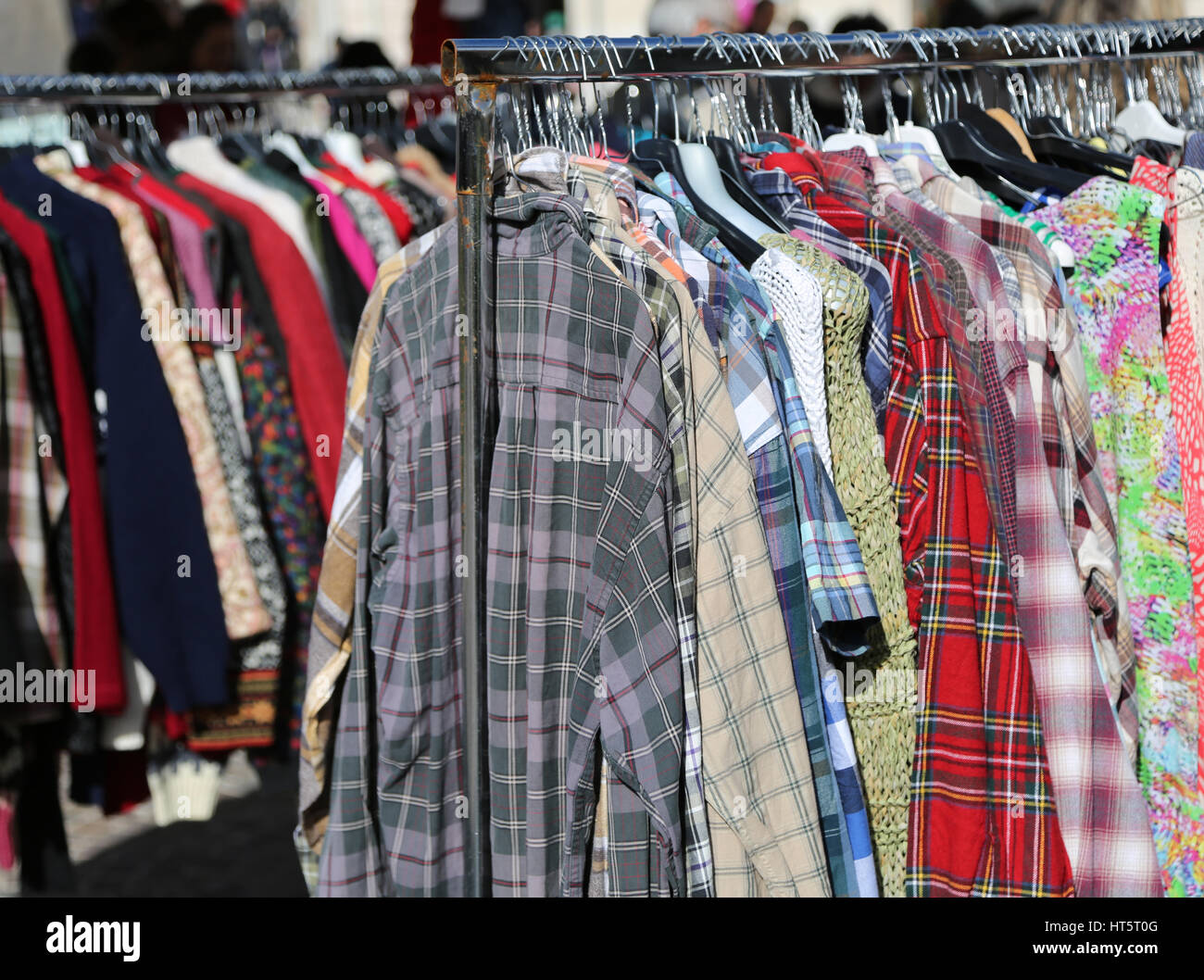 used clothes hung from hangers for sale in flea market Stock Photo - Alamy