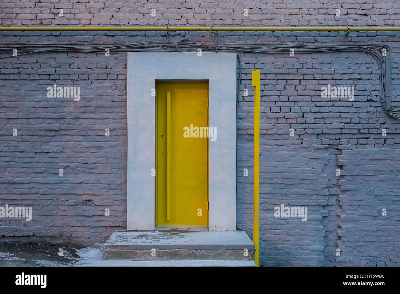 Entrance with a design yellow door to the office in a loft style on the ...