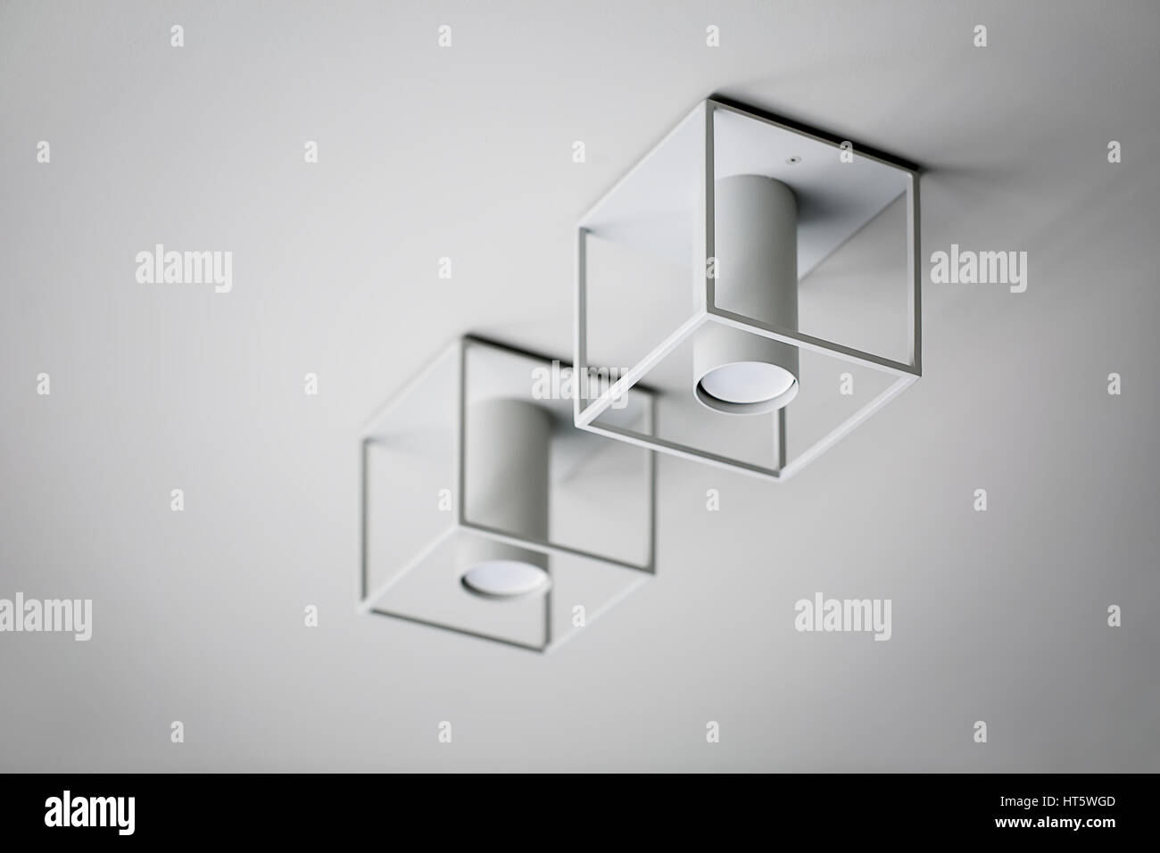 Two trendy light lamps on the light ceiling. Closeup. Horizontal Stock ...