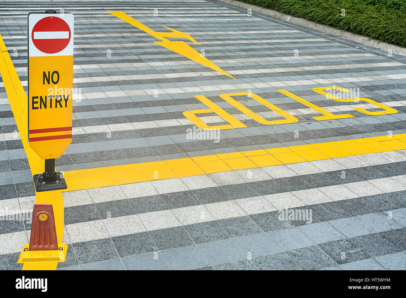 Tiled road with yellow road marking and a No Entry sign. There are ...