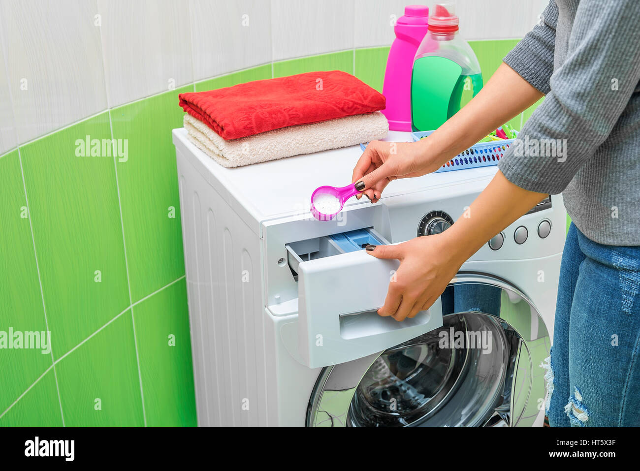Woman throws laundry detergent into the washing machine close-up Stock ...