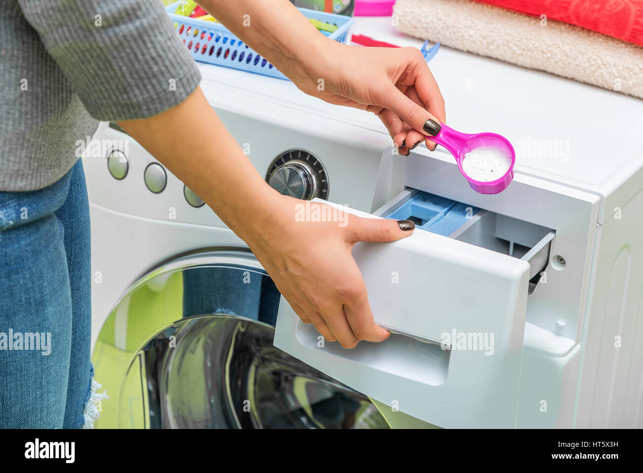 Woman throws laundry detergent into the washing machine close-up Stock ...