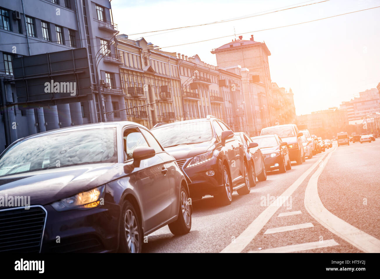 View from below to the lane with cars in traffic jam with warm sunlight ...