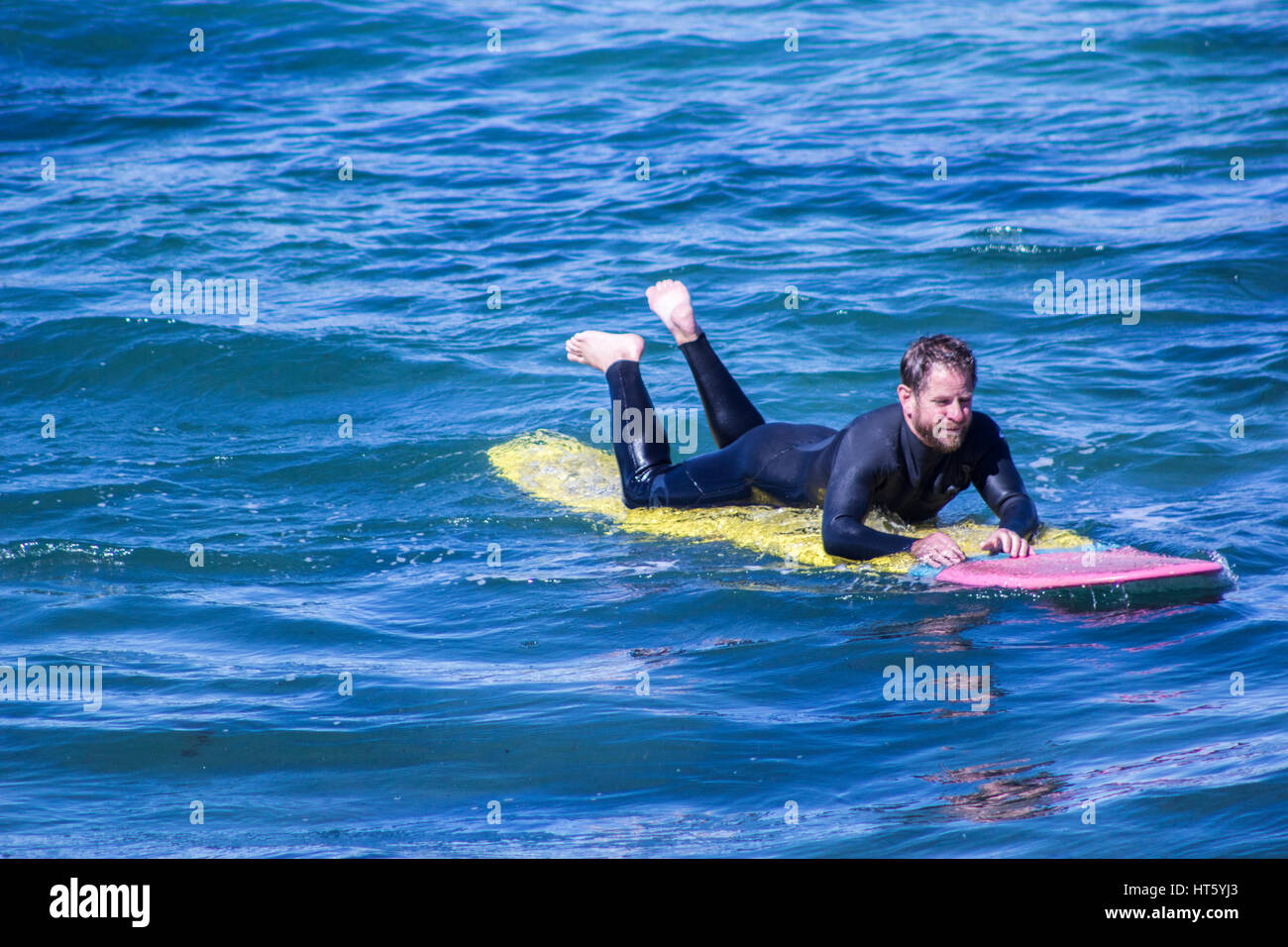 A surfer waiting for the good wave to come on pacific beach, San Diego ...