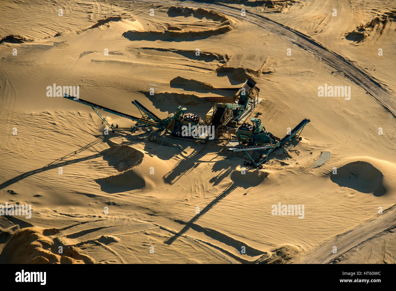 Aerial view of sand crushing machine amidst sand dunes Stock Photo - Alamy