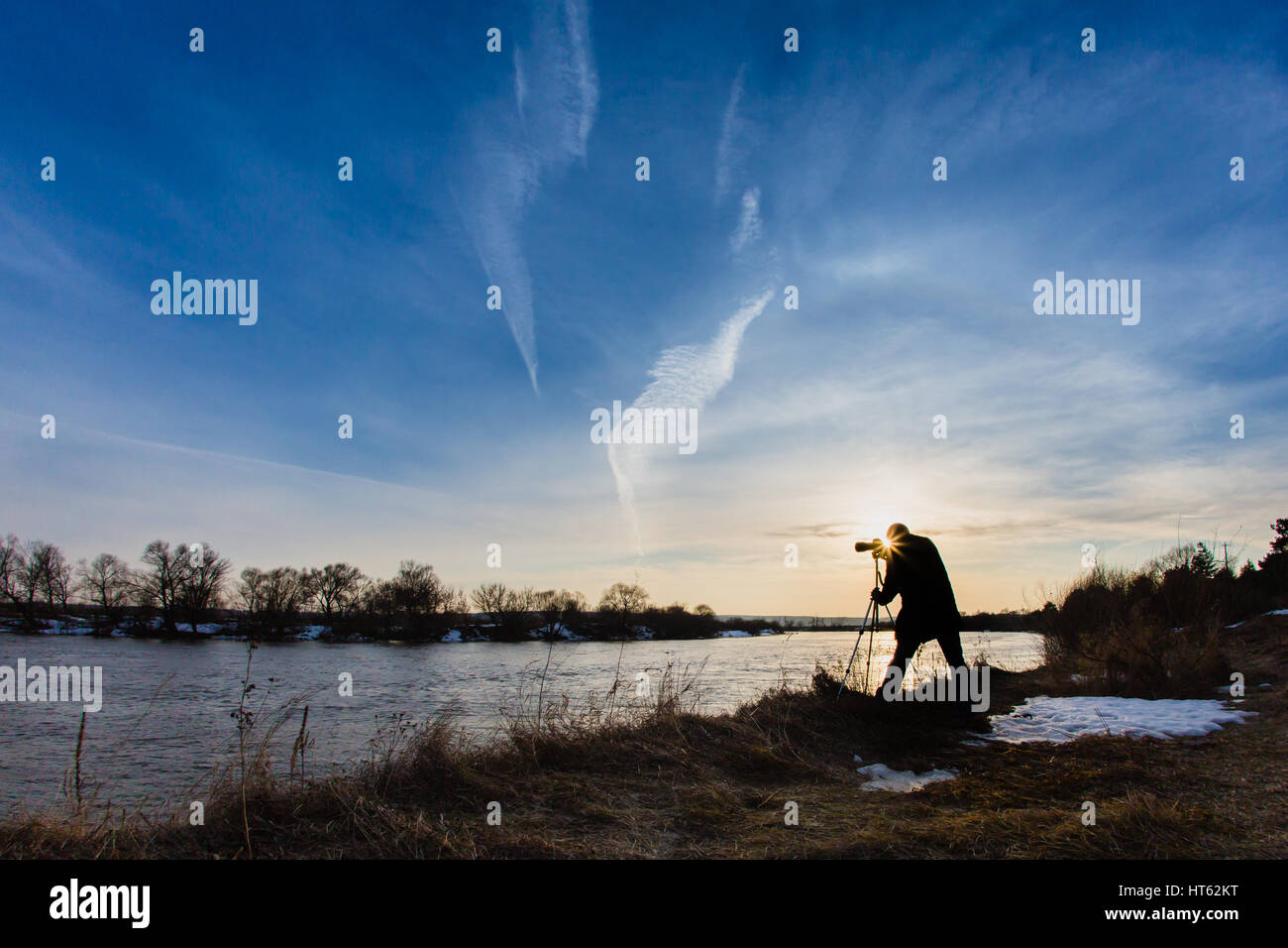 Professional photographer taking a photo flooding river at sunset Stock ...
