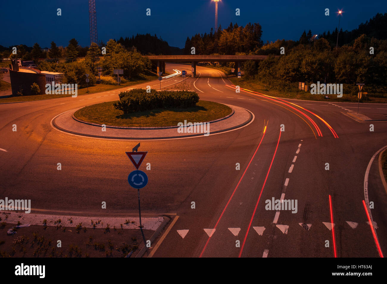 Traffic intersection/roundabout at dusk, with light trails from cars ...