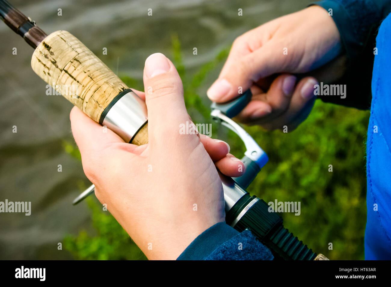 Closeup of female hands, holding fishing rod and reel Stock Photo - Alamy