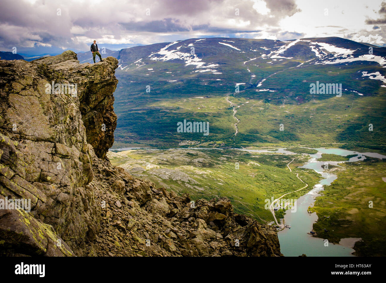 Man standing at edge of cliff at Mount Besseggen, Norway Stock Photo ...