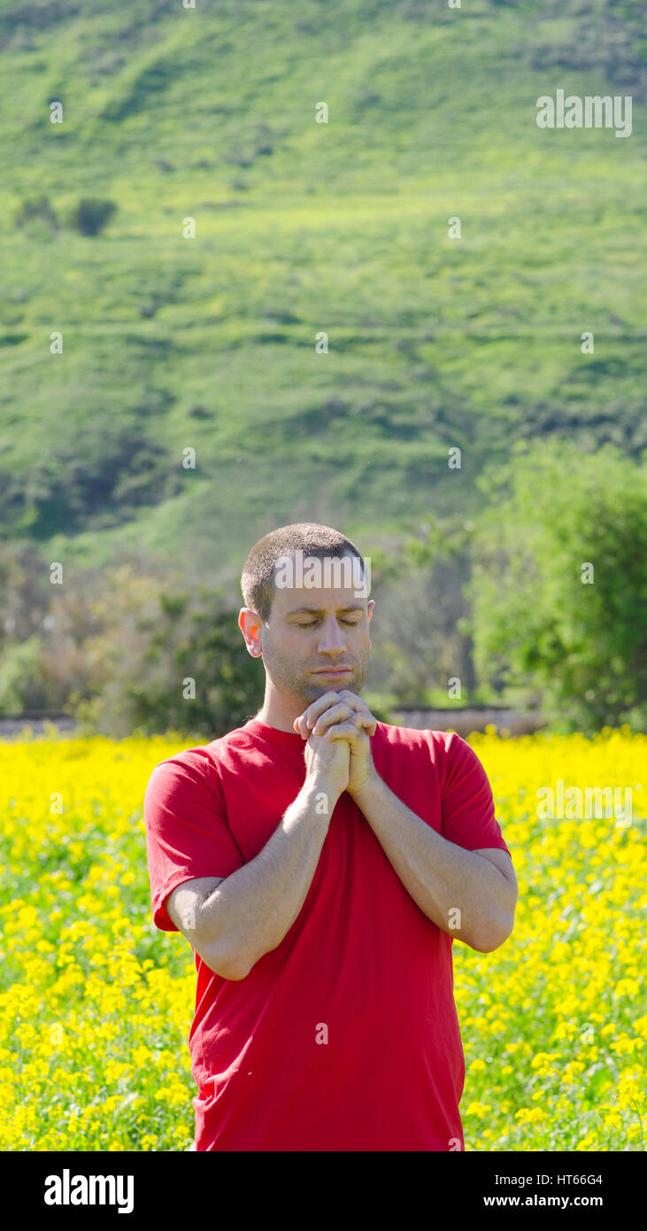 Solitude man praying with hands clasped in nature Stock Photo - Alamy